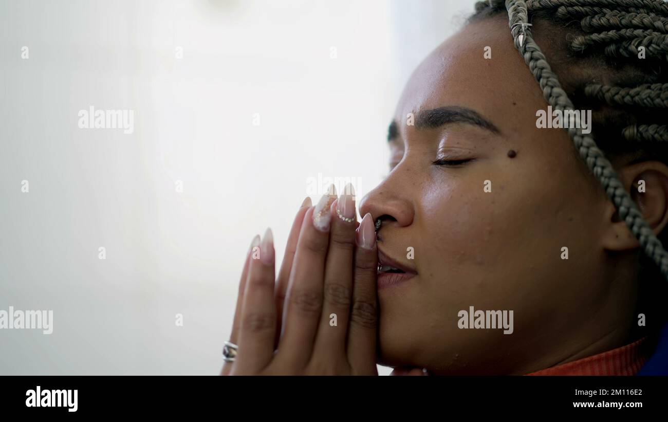 A spiritual young black latina woman praying to God. Repentant African ...