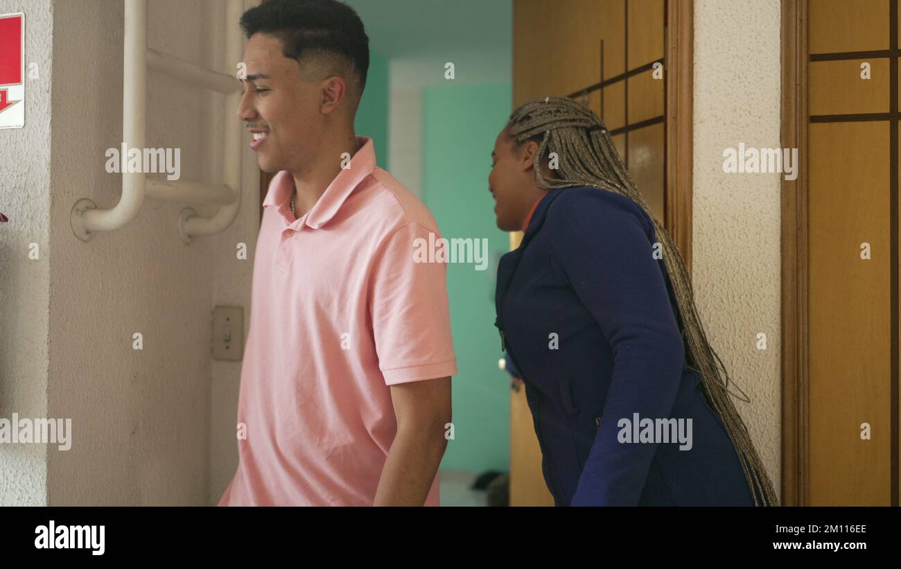 A young black woman closing entrance door. African American adult girl ...