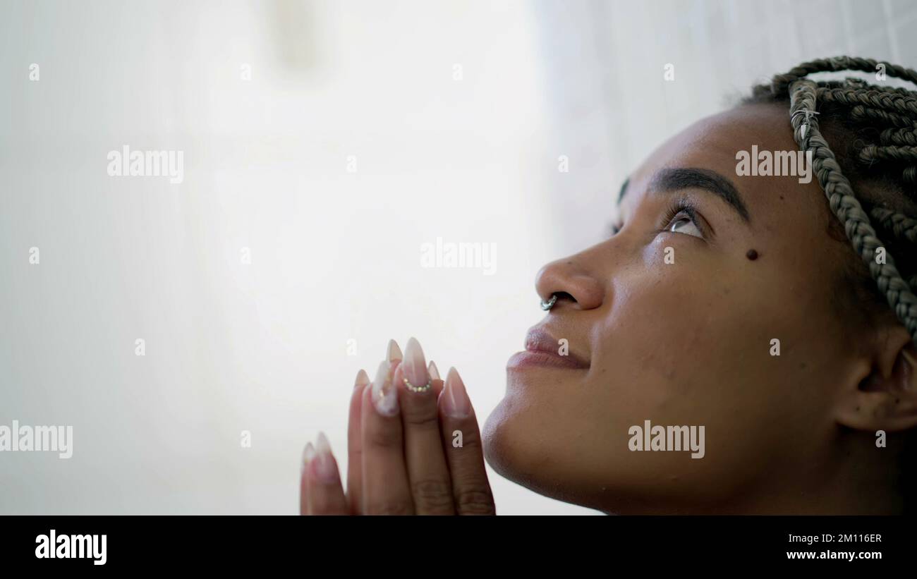 A spiritual young black latina woman praying to God. Repentant African ...