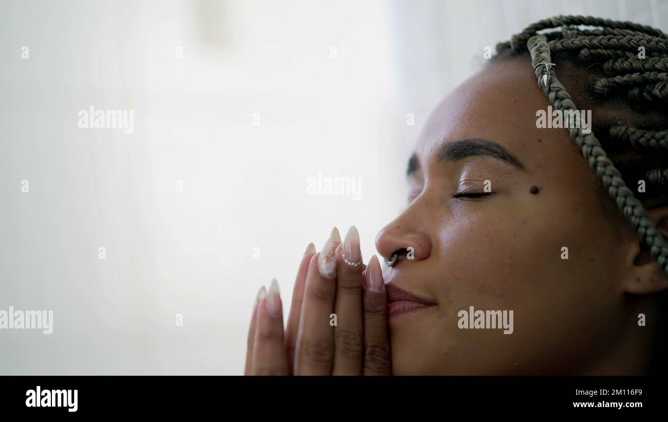 A spiritual young black latina woman praying to God. Repentant African ...