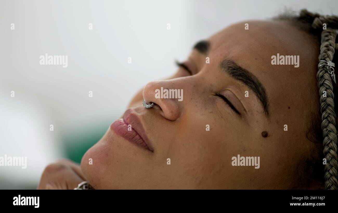 Closeup young hispanic woman face looking at sky smiling. Hopeful ...