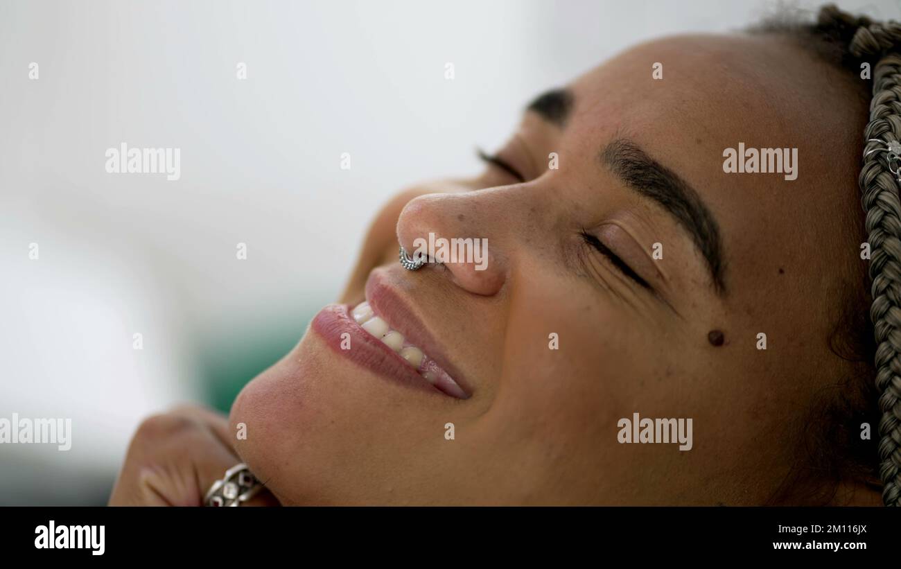 Closeup young hispanic woman face looking at sky smiling. Hopeful ...