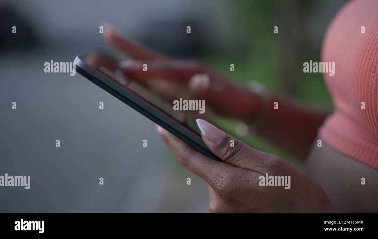 Female Person holding tablet outside. A black latina adult girl hand ...