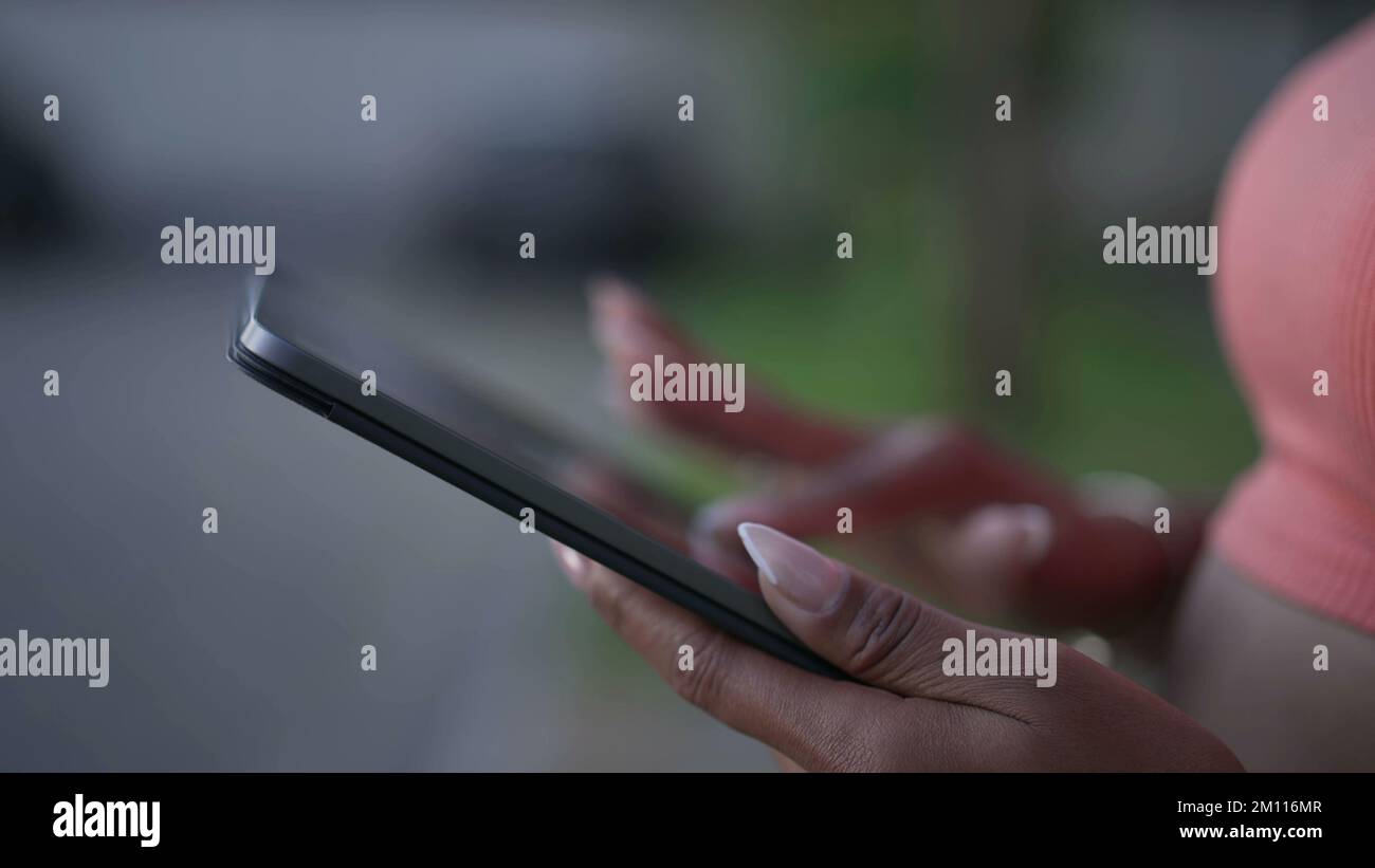 Female Person holding tablet outside. A black latina adult girl hand ...