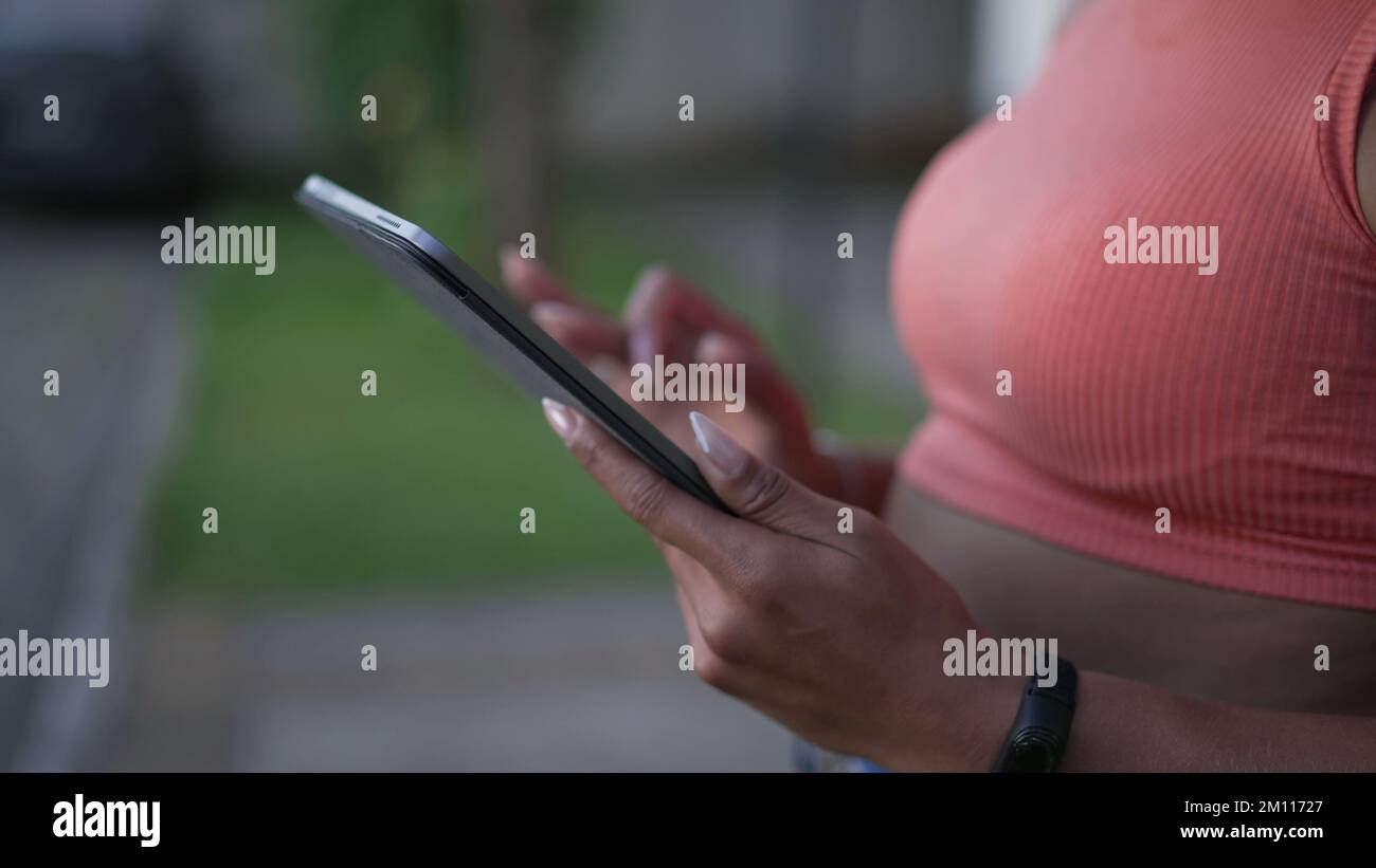 One young black woman using tablet outdoors. African American adult ...