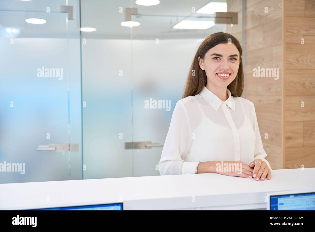 Smiling happy female visitor posing for camera at front desk Stock ...