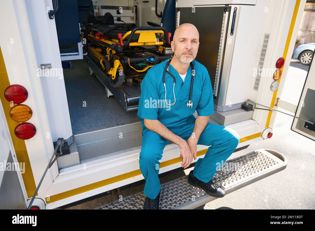 Medical officer sits near the open cockpit of a car Stock Photo - Alamy