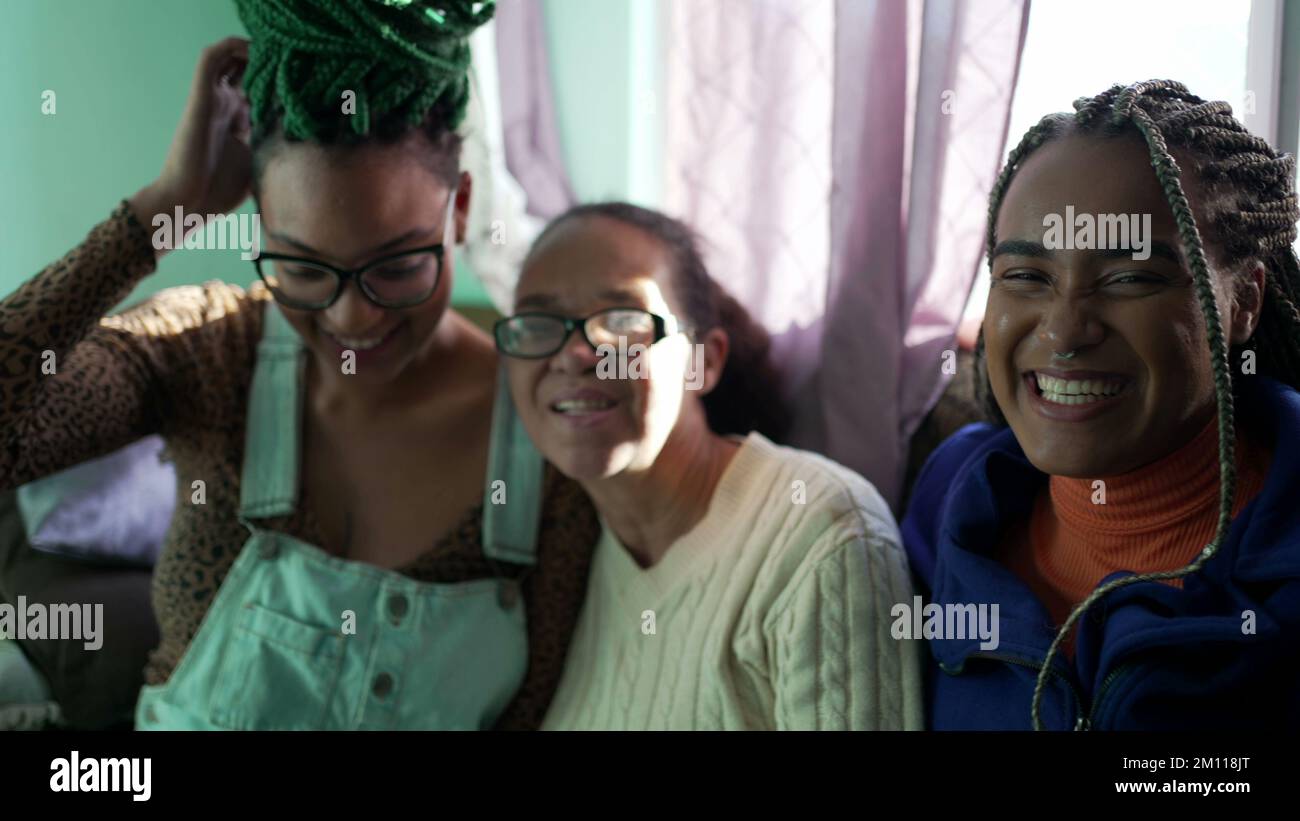 Happy Brazilian women seated at couch laughing together. Joyful South ...