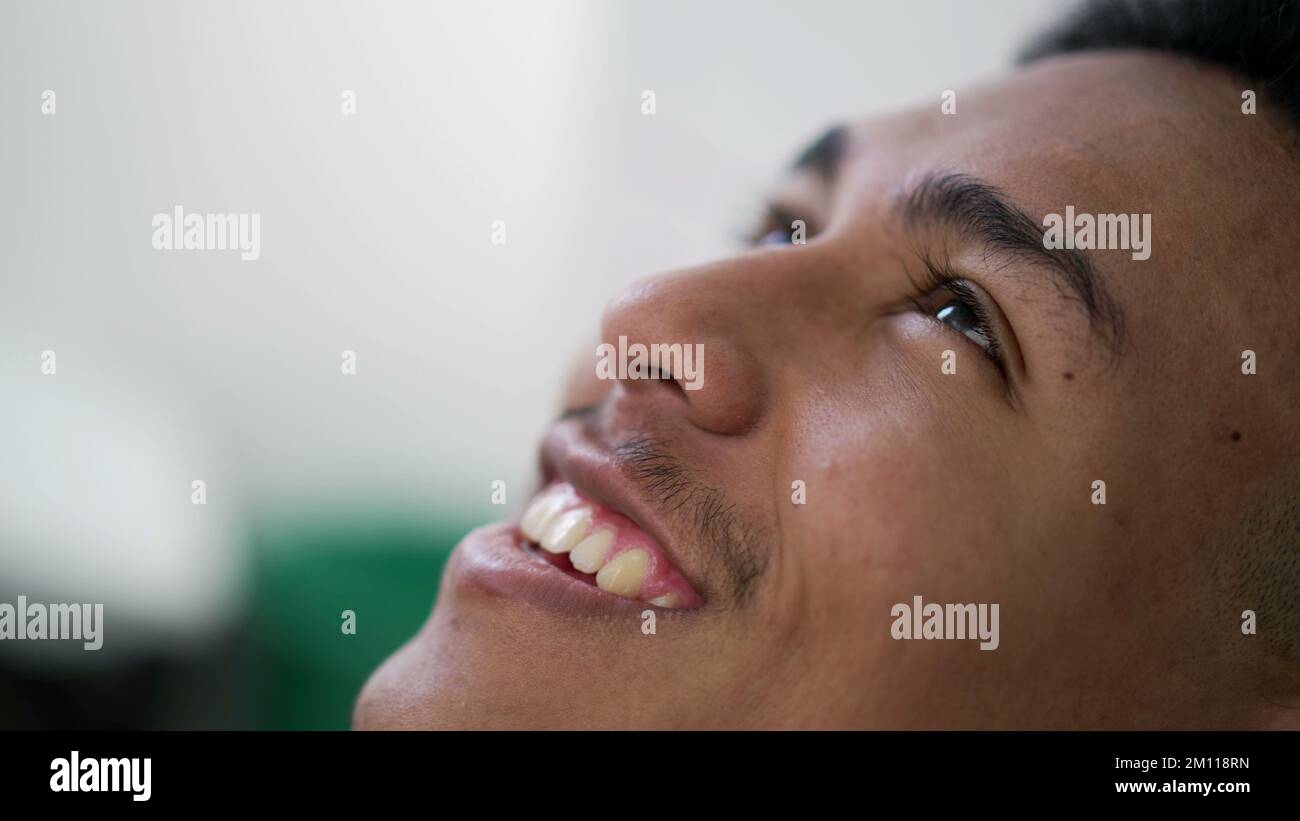 Hispanic young man closeup face looking at sky in contemplation. South ...