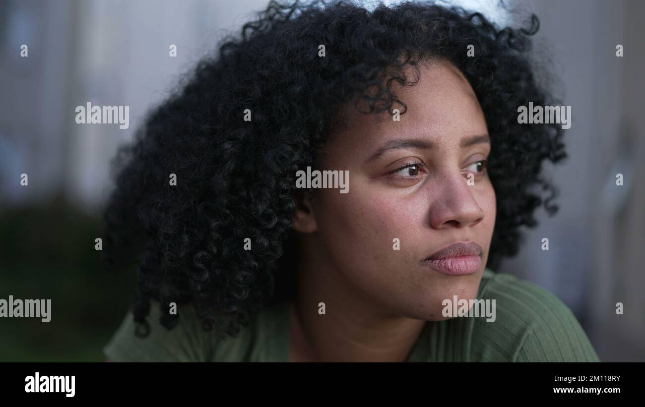 One contemplative young black woman closeup face. Pensive Brazilian ...