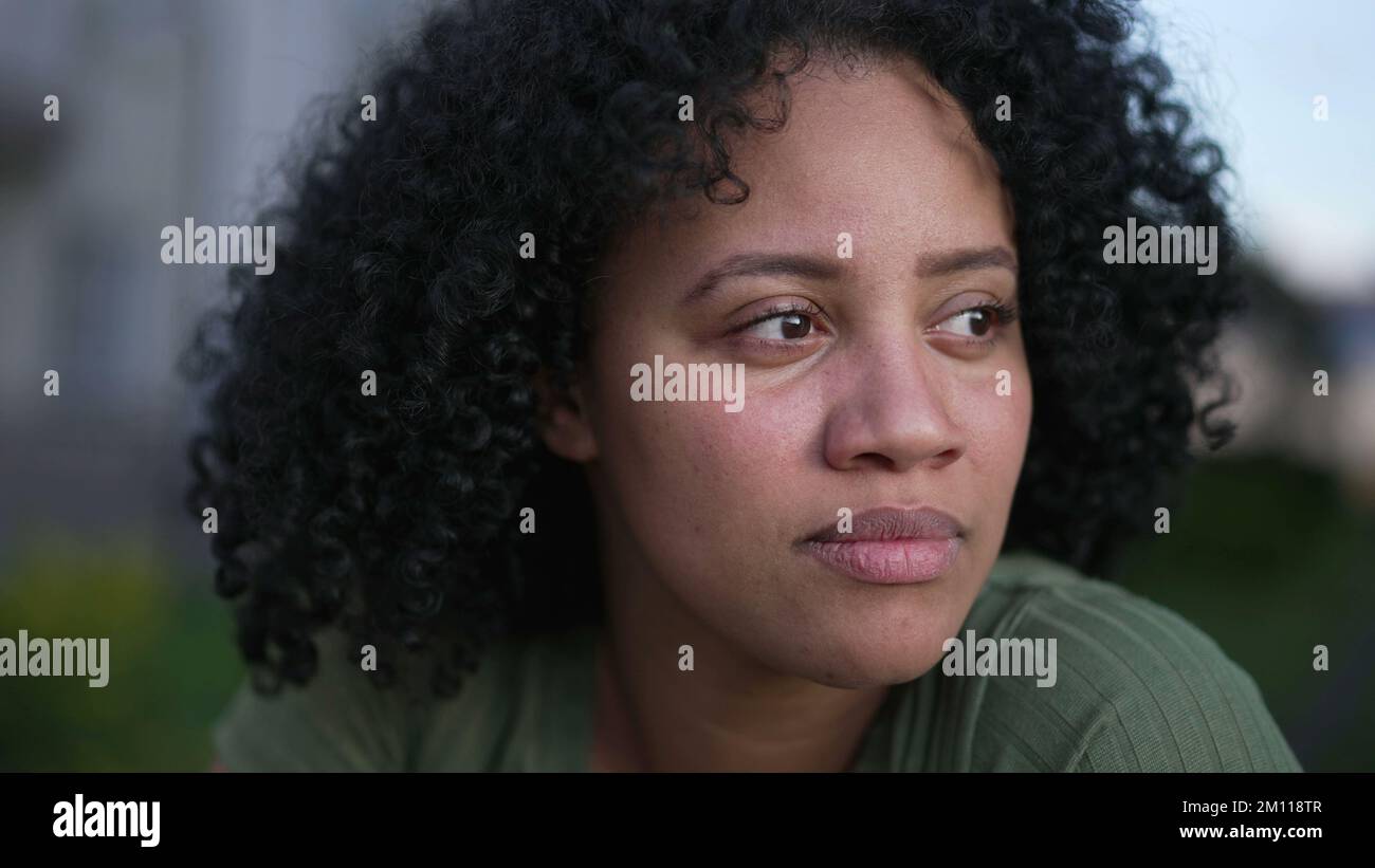 One contemplative young black woman closeup face. Pensive Brazilian ...