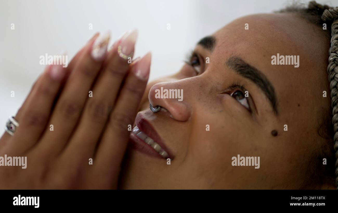 One black woman closing eyes in prayer. African American closeup face ...