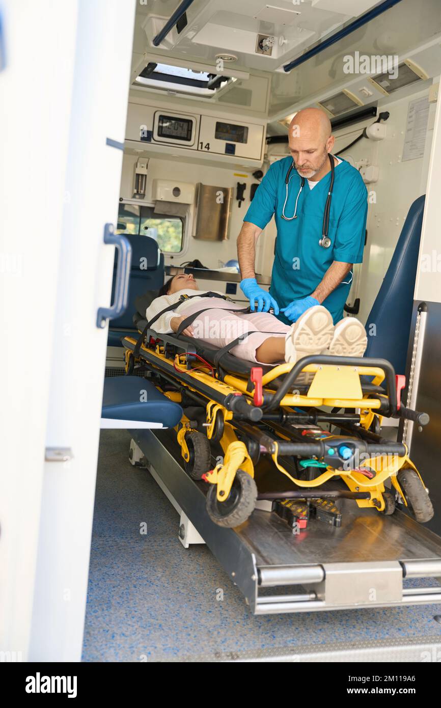 Doctor fixes body of an injured woman on a gurney Stock Photo - Alamy