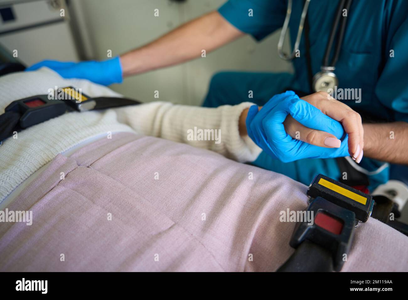 Woman grabs hand of doctor while being transported by ambulance Stock ...