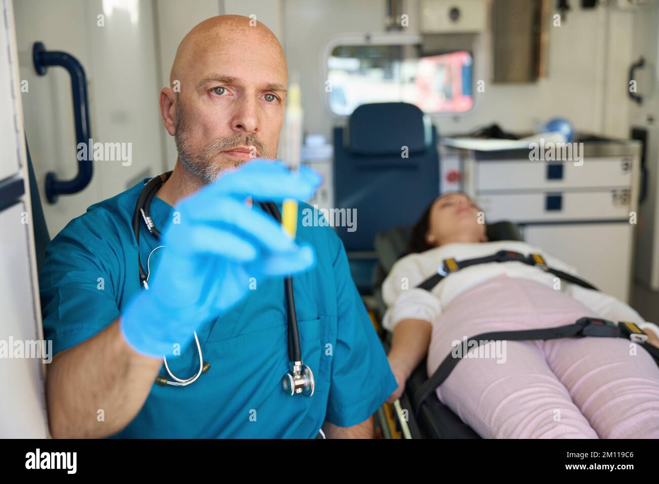 Doctor holding filled syringe for an injection to female patient Stock ...