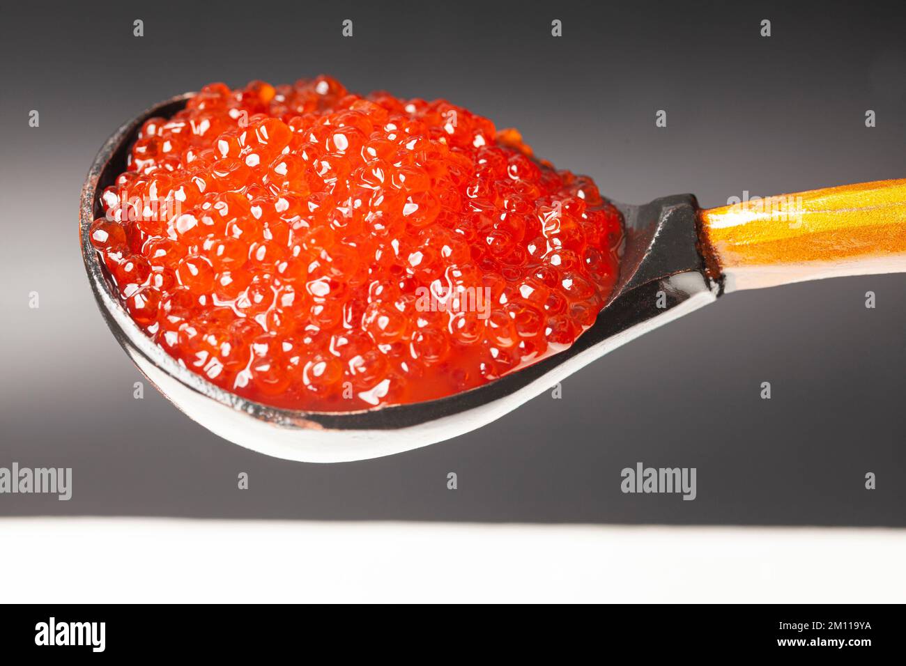 Delicious red caviar in wooden spoon on black white background Stock ...