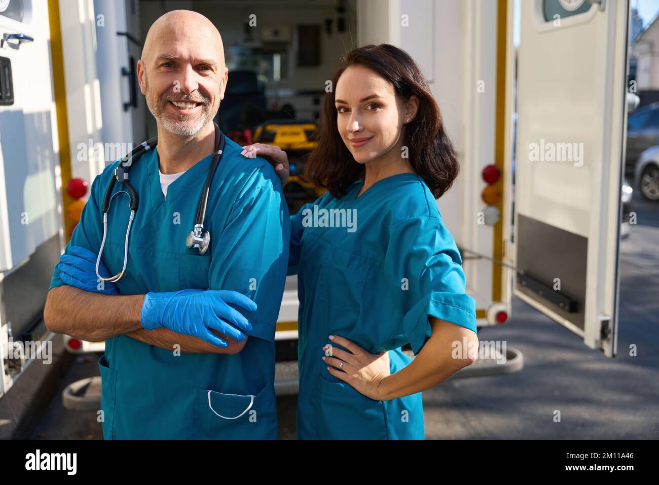 Two colleagues from ambulance team pose next to hospital car Stock ...