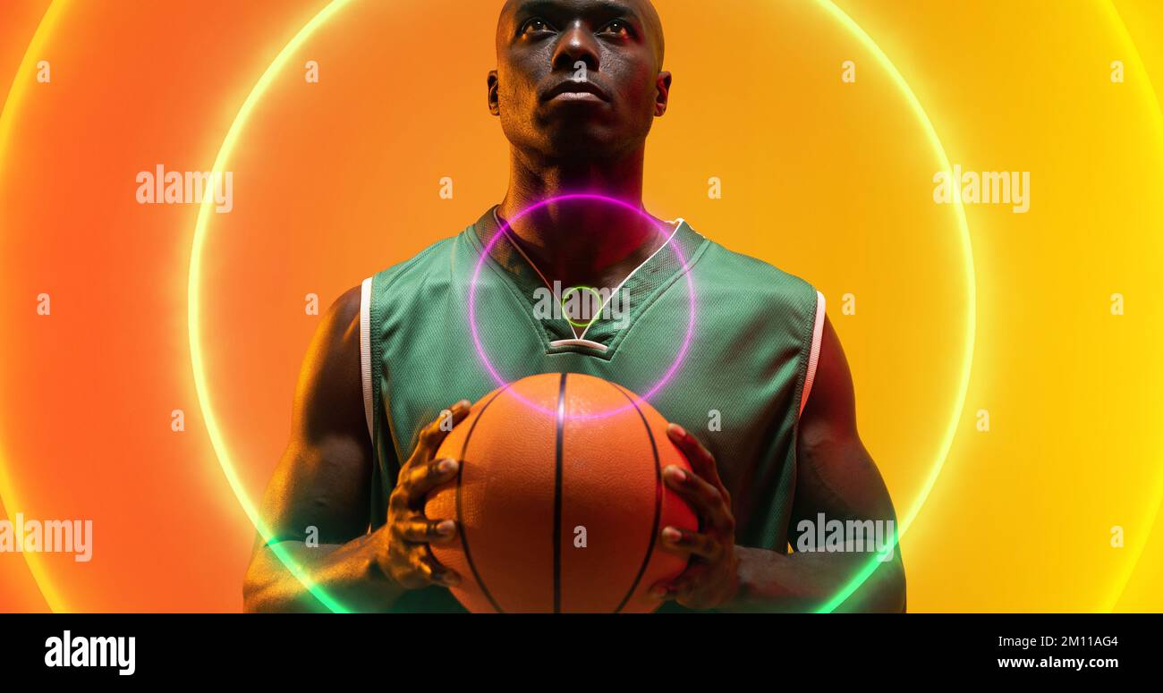 Composite of illuminated circles over african american basketball ...