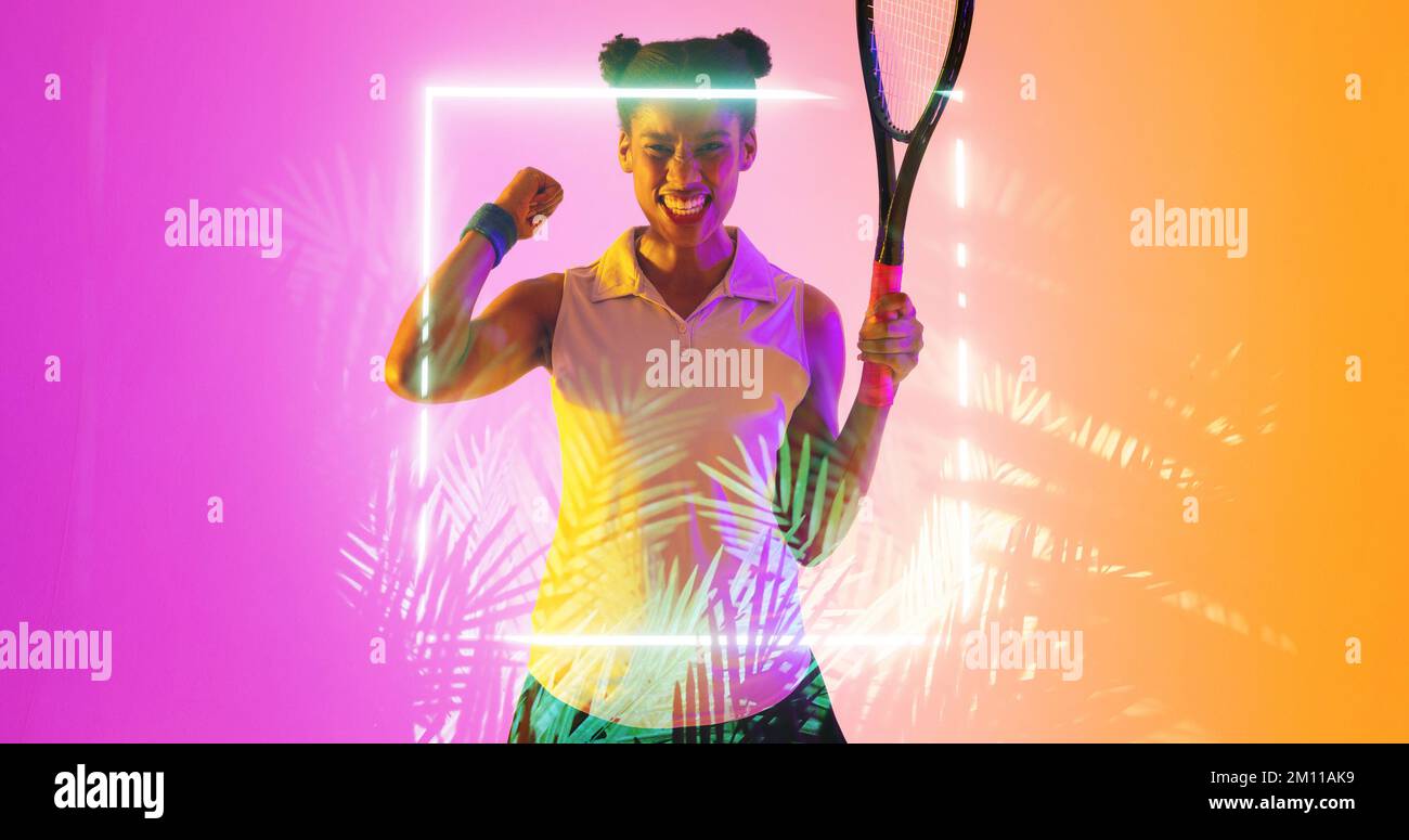 Cheerful biracial tennis female player with racket clenching teeth by ...