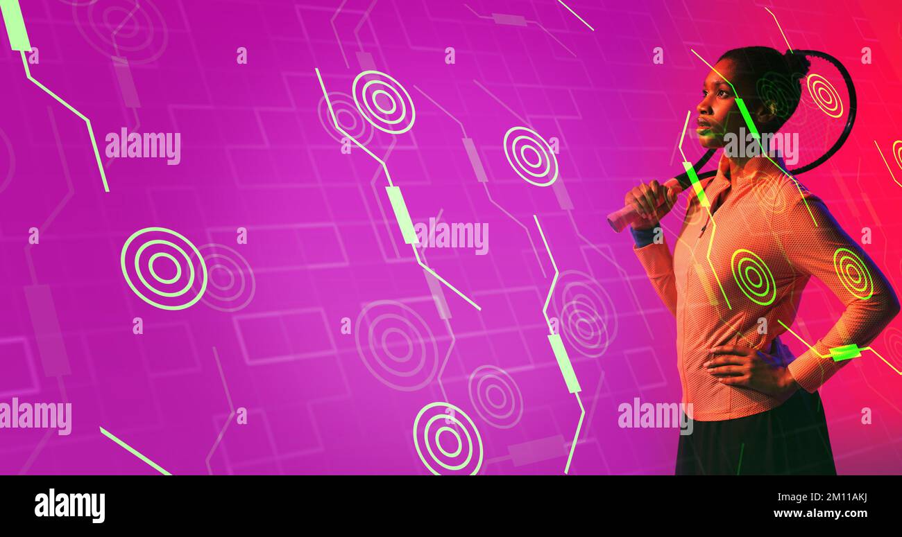 Side view of biracial female player with racket standing on illuminated ...