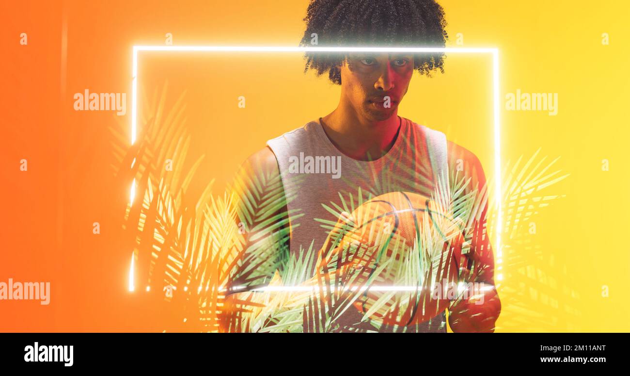 Biracial basketball player with afro hair holding ball and looking away ...