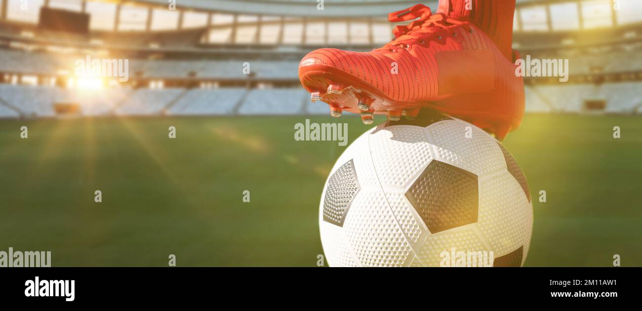 Low section of player with soccer ball in stadium on sunny day, copy ...