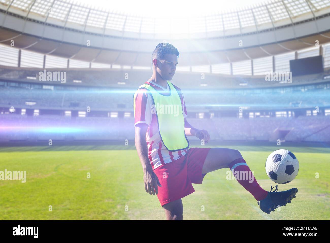 Biracial young soccer player practicing with ball in stadium, copy ...