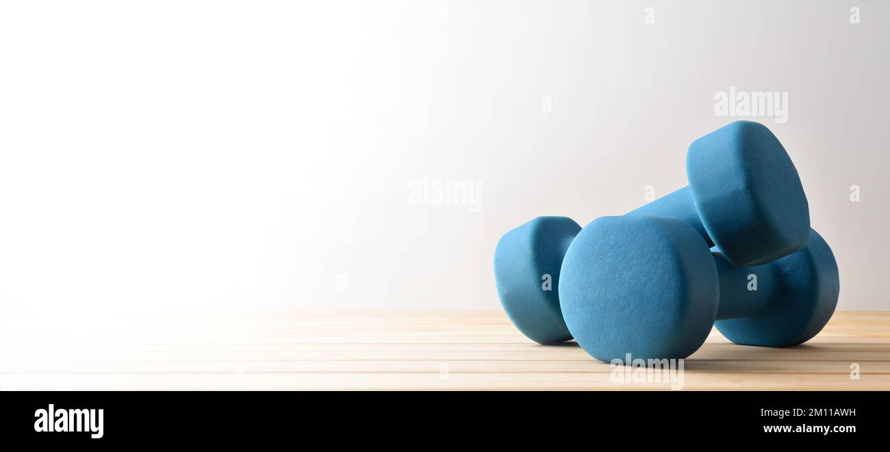 Background with two blue dumbbells on wooden floorboard and white ...