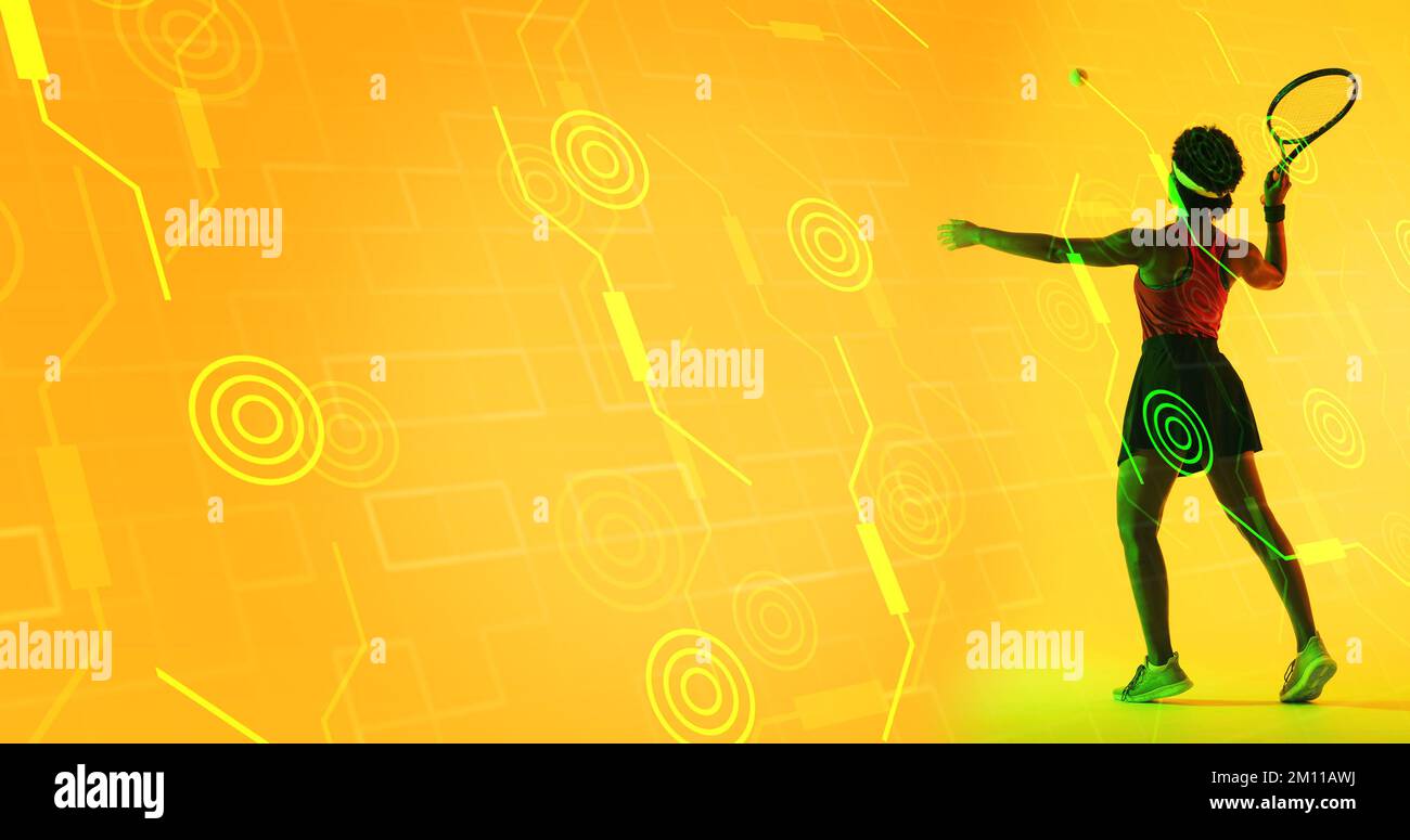 Rear view of biracial female tennis player striking ball with racket ...