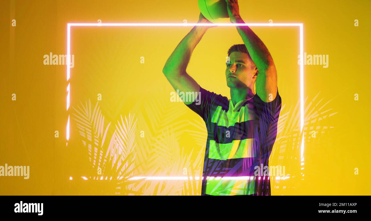 Caucasian rugby player throwing ball by illuminated rectangle and ...