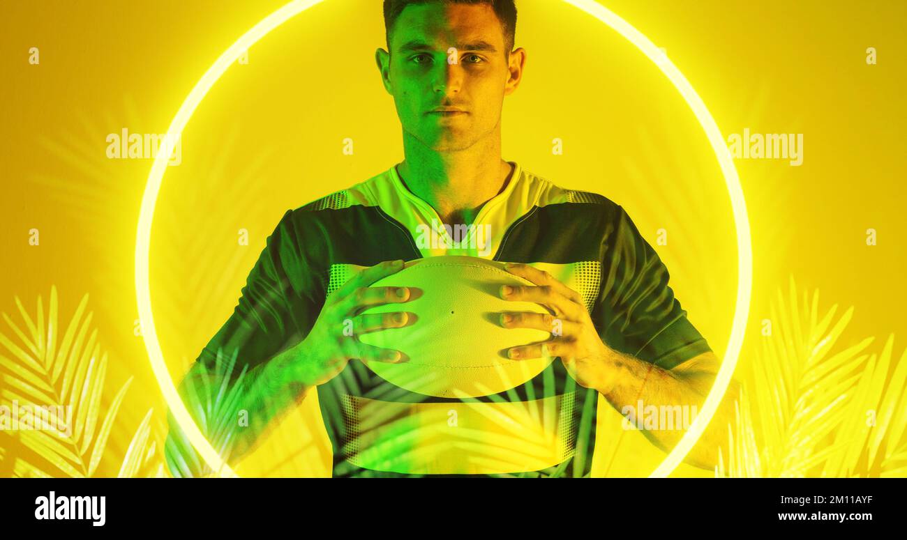 Caucasian male player holding rugby ball over illuminated circle and ...