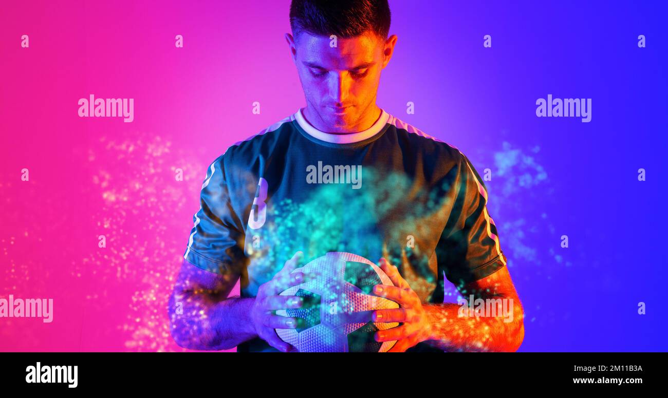 Caucasian young soccer player holding ball with abstract design over ...