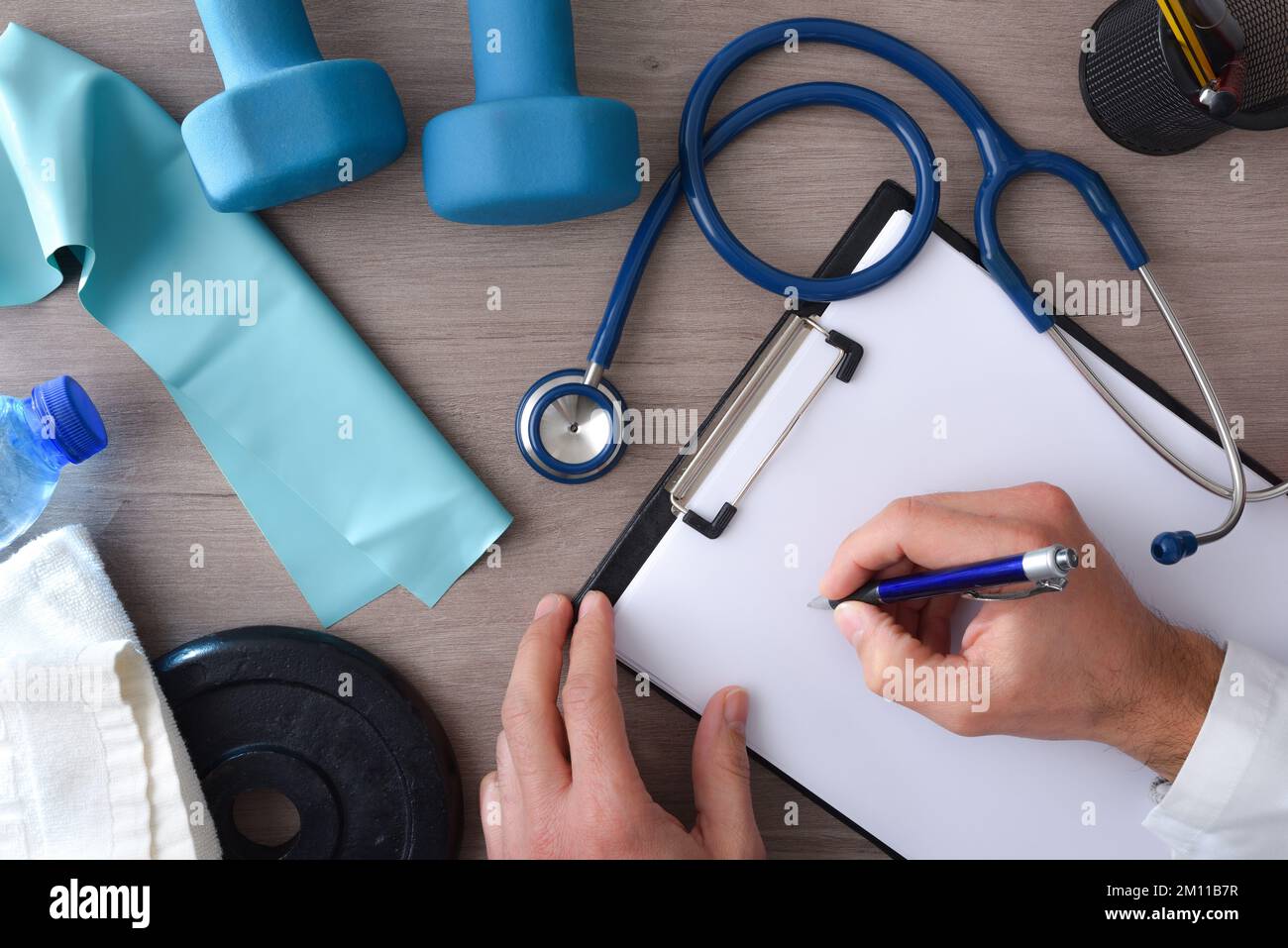 Sports doctor taking control notes in a folder on table with ...
