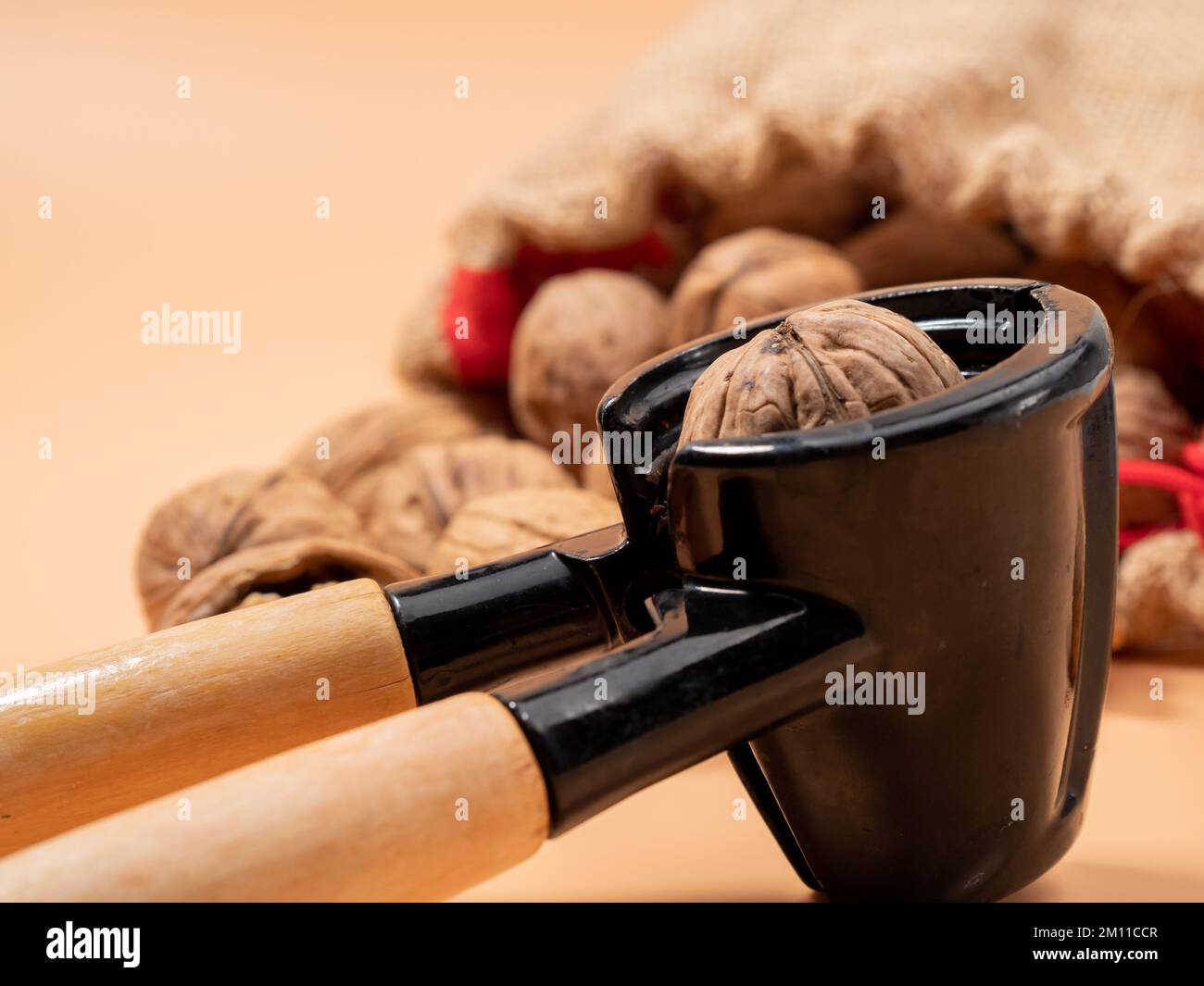 Walnut and nutcracker on orange background. Raw walnut. Close-up Stock ...