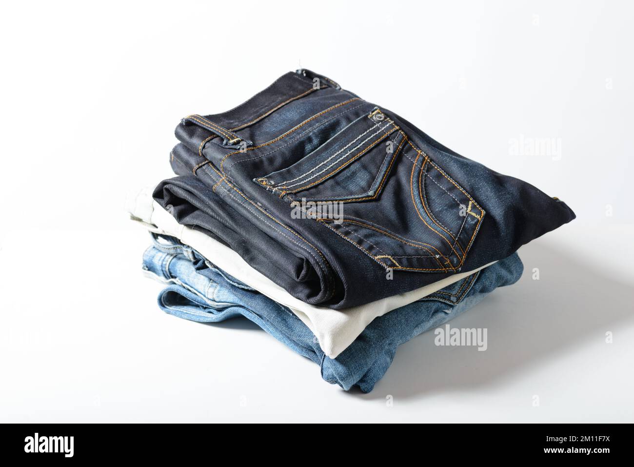 A pile of jeans on a white background Stock Photo - Alamy