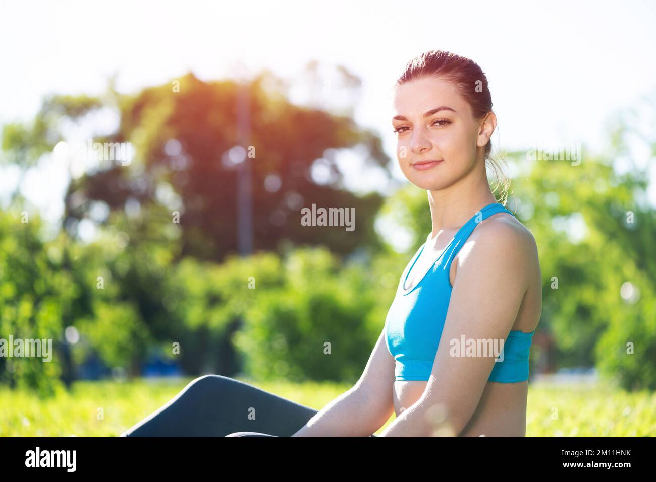 Beautiful smiling girl in sportswear relax in park Stock Photo - Alamy