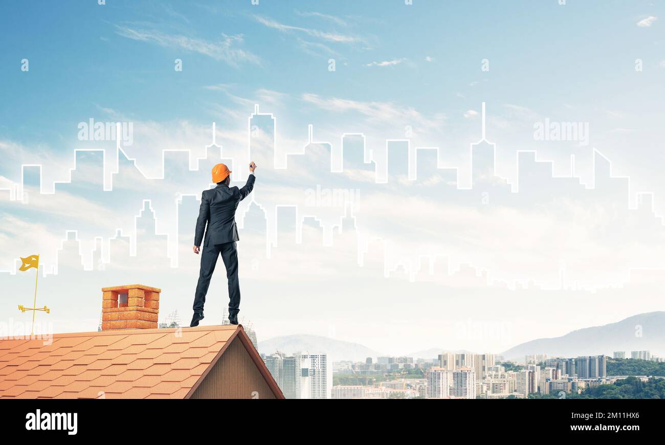 Man architect draw silhouette of modern city on blue sky. Mixed Stock ...