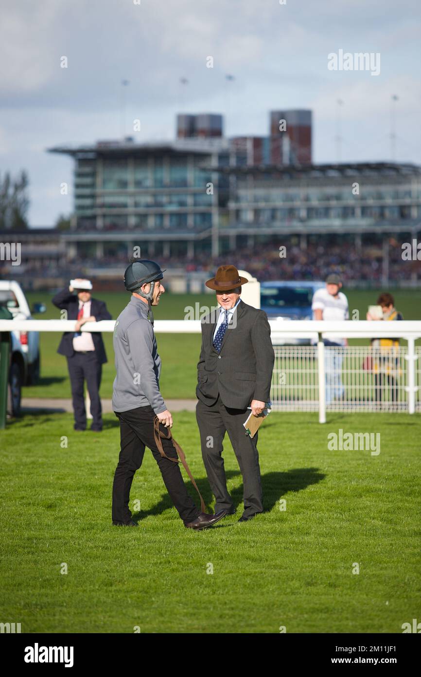 Racecourse staff chatting before the jockeys and their horses arrive at ...