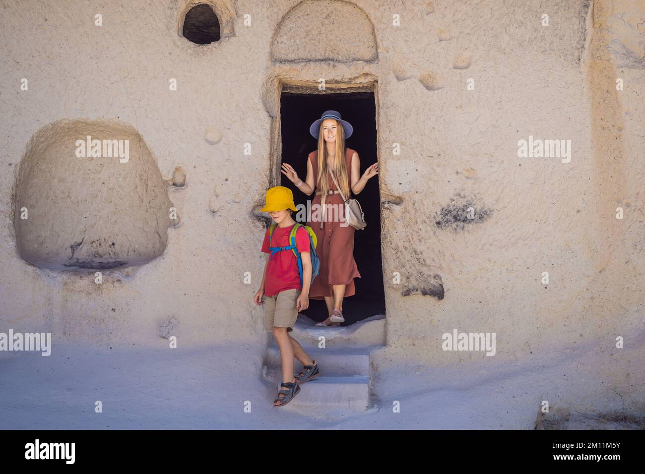 Mom and son tourists exploring valley with rock formations and fairy ...