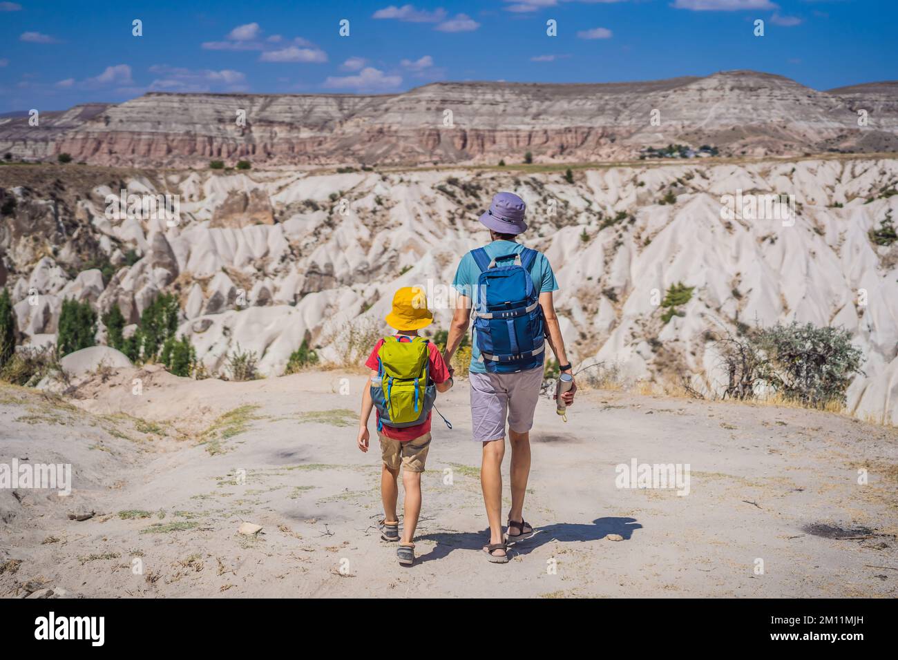 Father and son tourists exploring valley with rock formations and fairy ...