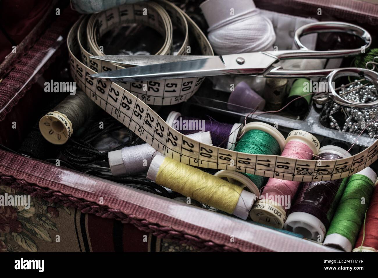 colored threads and various accessories for sewing inside a sewing box ...