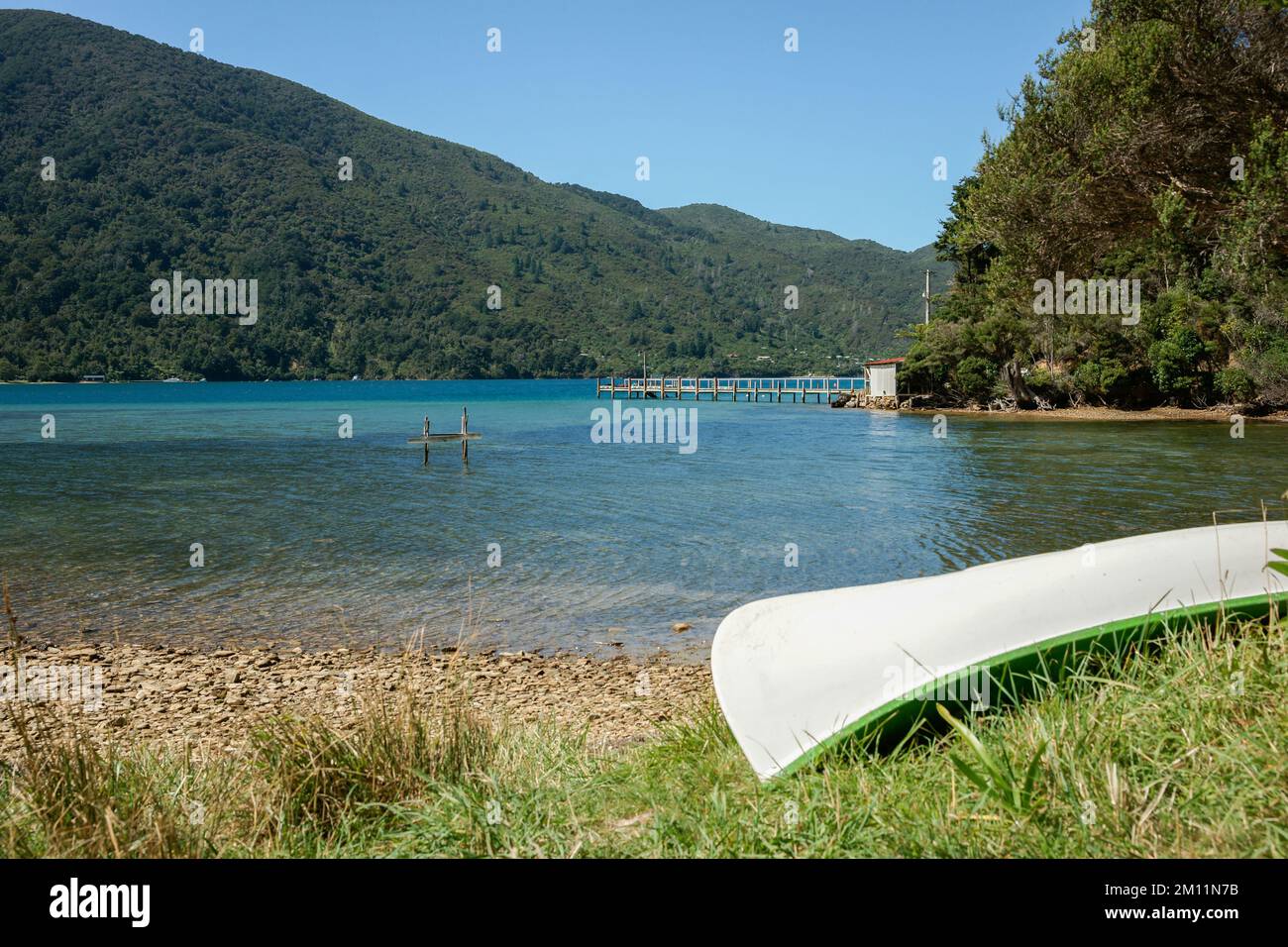 Upturned kayak on beach in picturesque Marlborough Sounds bay in South ...