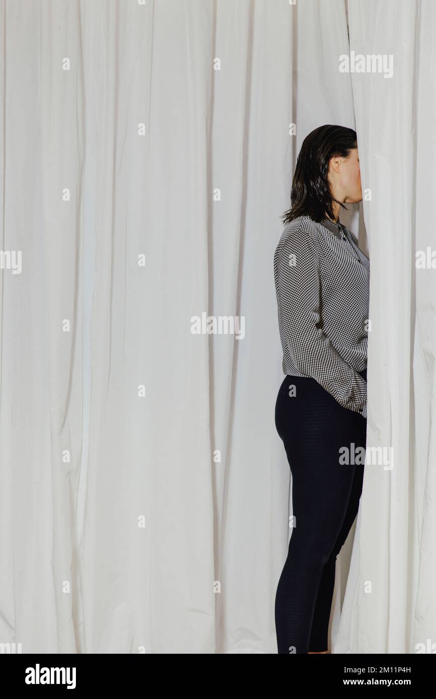 Side view of woman with face behind curtain Stock Photo - Alamy