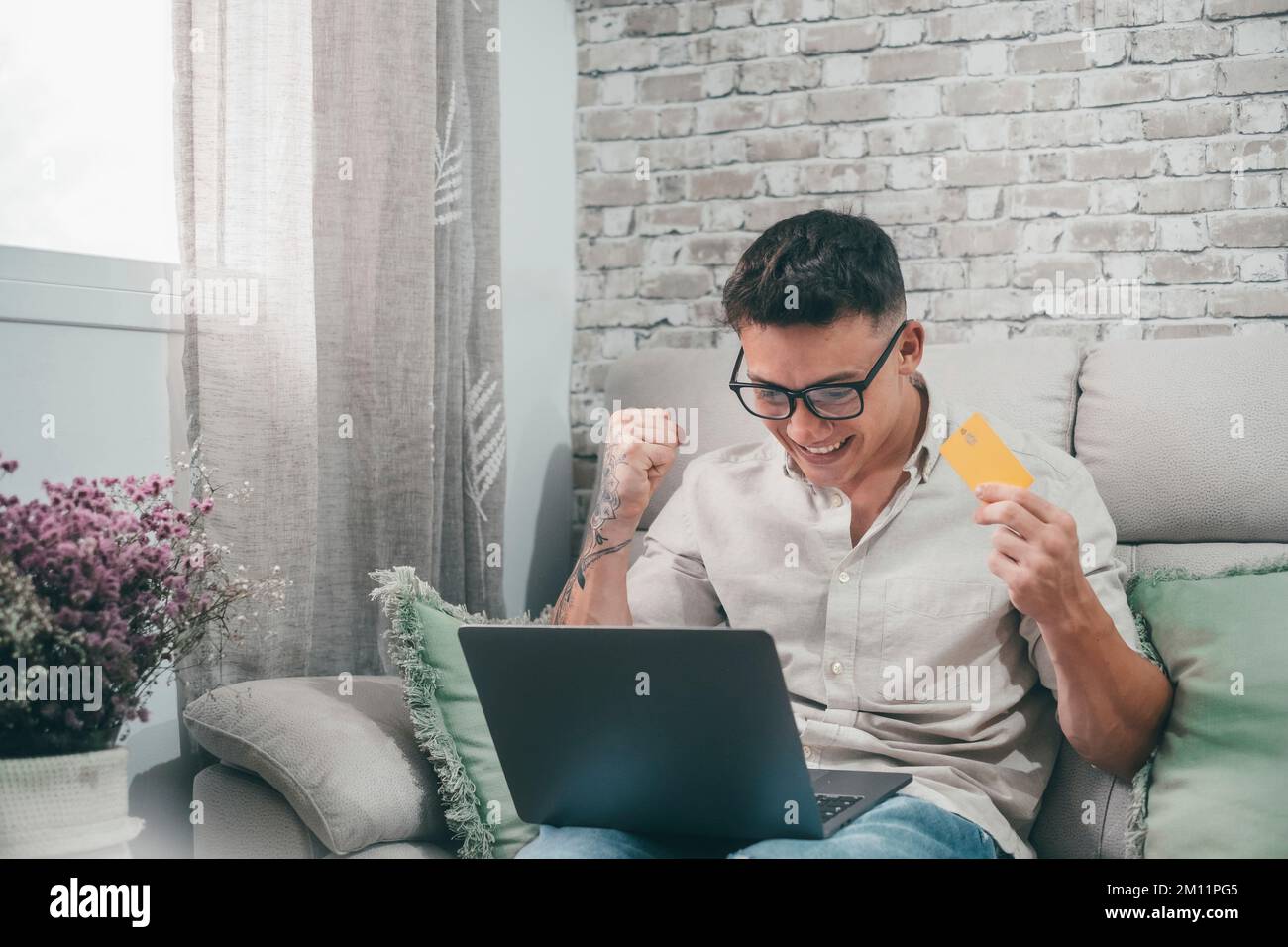 One young man using laptop and buying on online store. Happy boy using ...