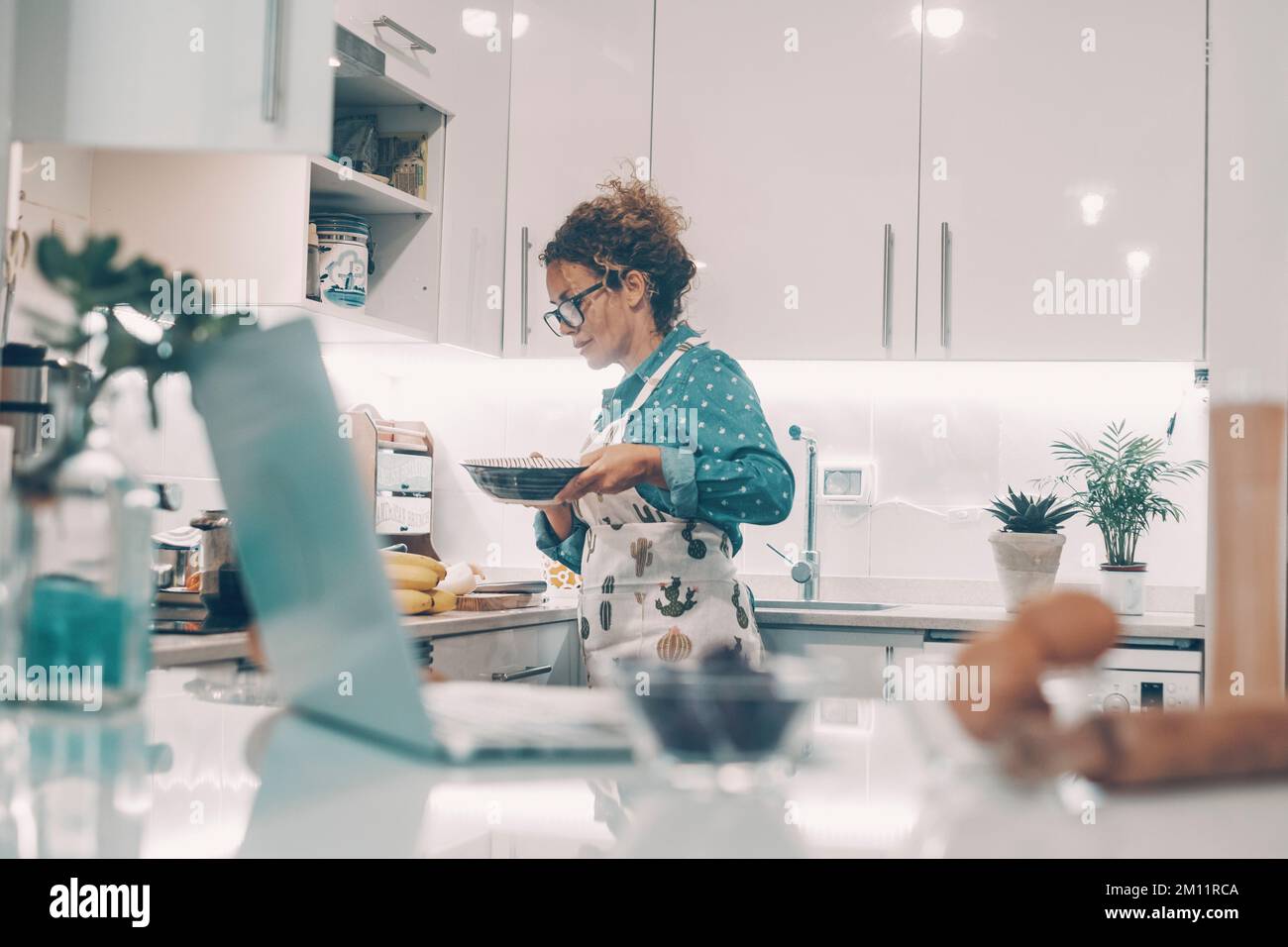 Happy woman alone at home cooking lunch with a smile. Ingredients and ...
