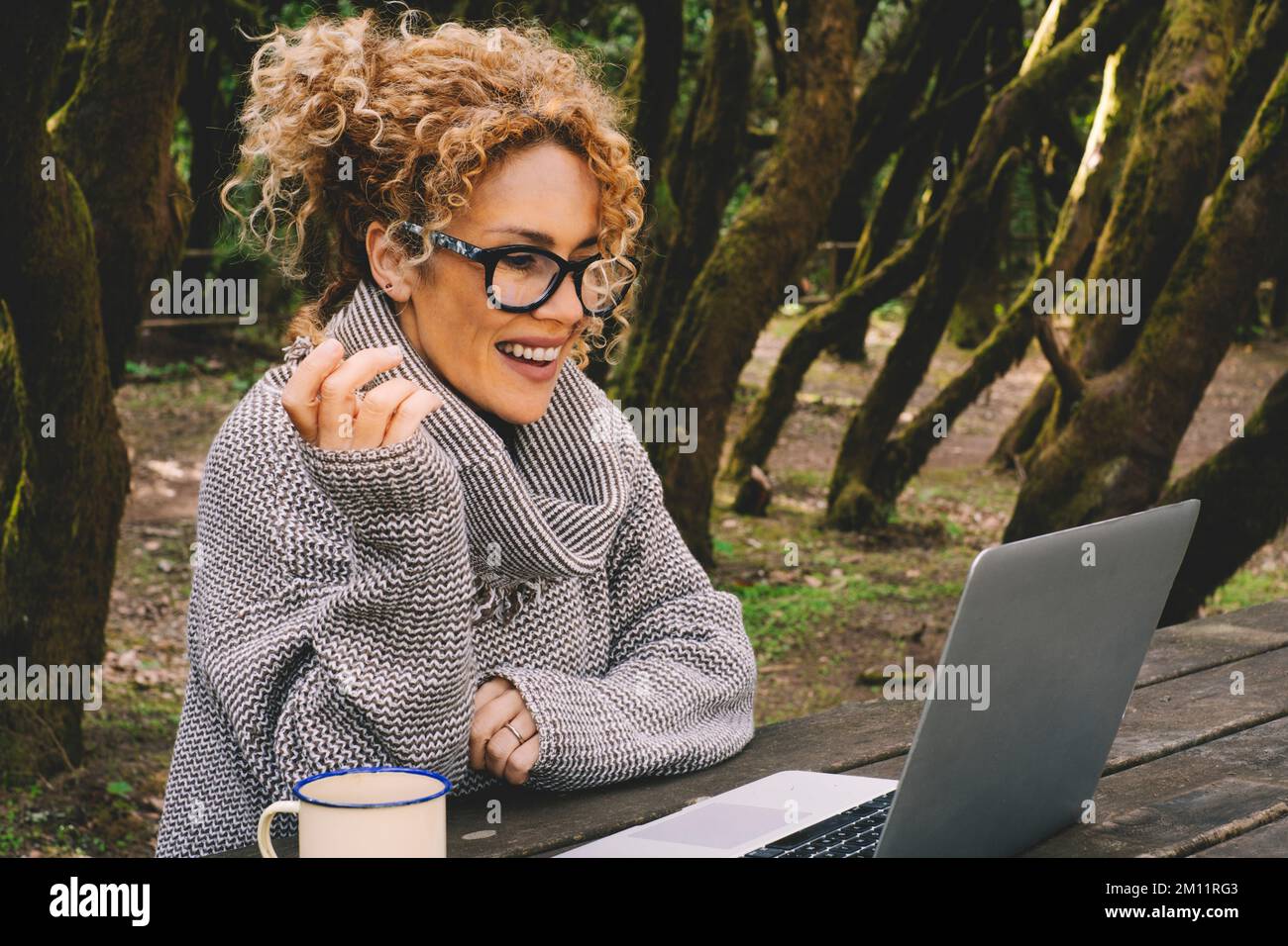 Cheerful young woman doing video call conference on laptop computer ...