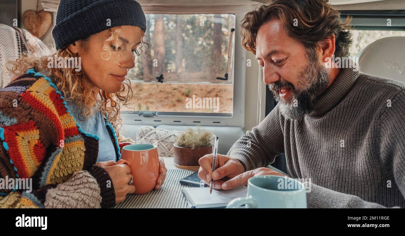 Couple plan travel destination from inside a camper van. Man and woman ...