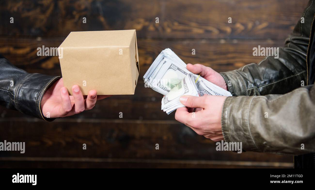 Cash money and box with forbidden goods exchange. Illegal deal concept ...