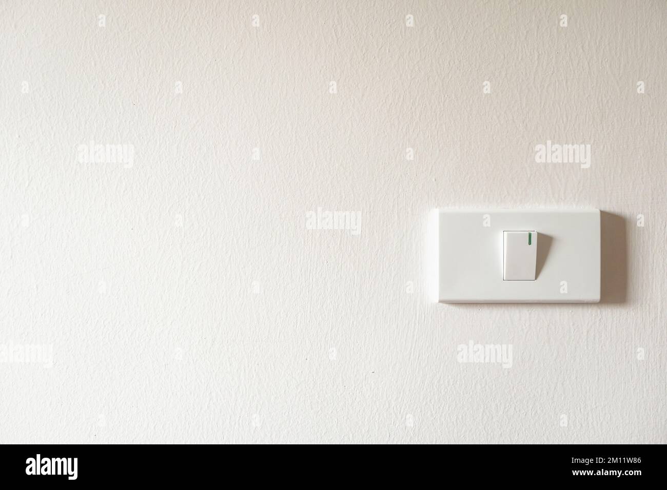 room light switch on white concrete wall Stock Photo - Alamy