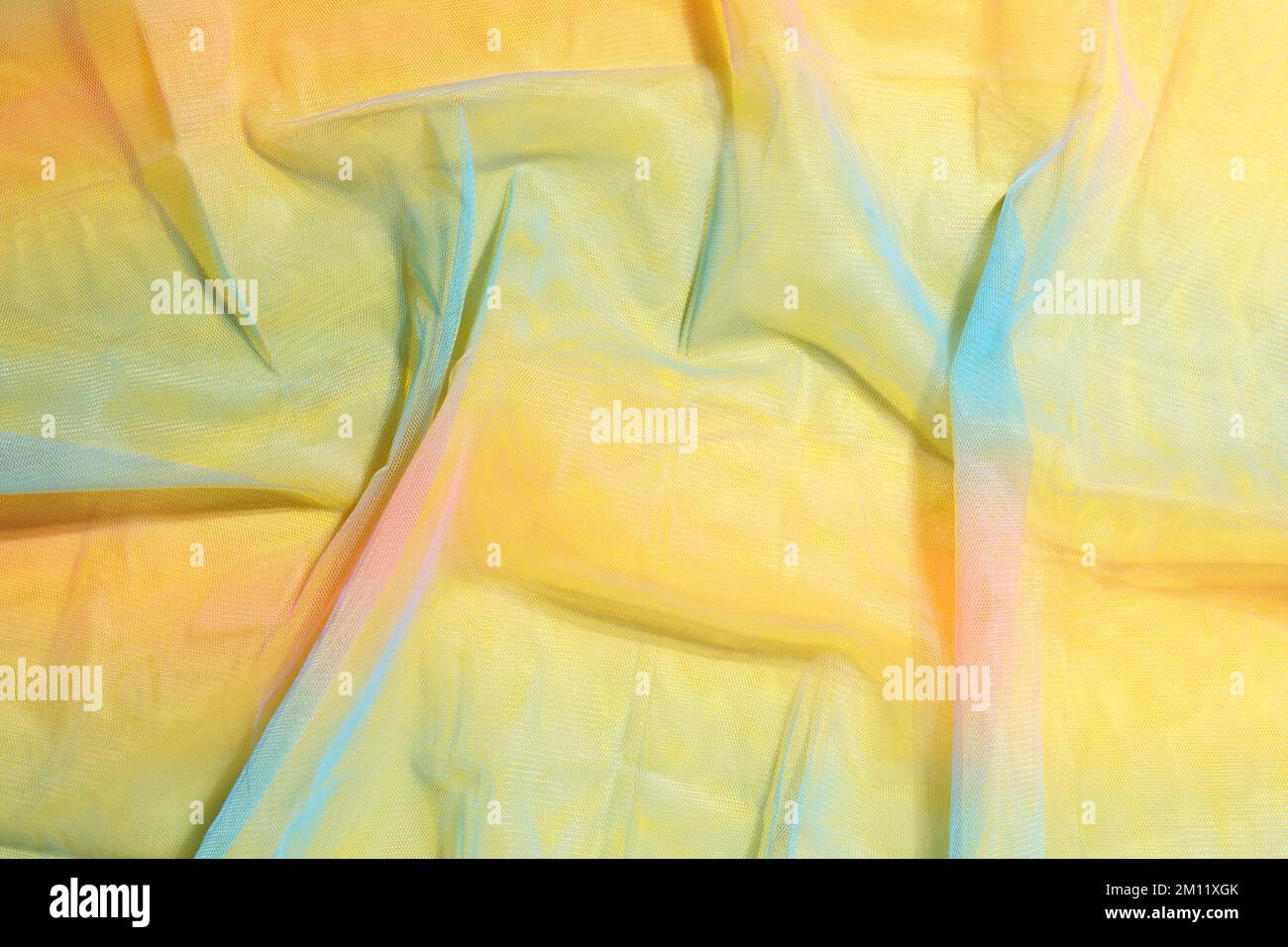 Rainbow yellow fabric background. Silk fabric in iridescent colors ...